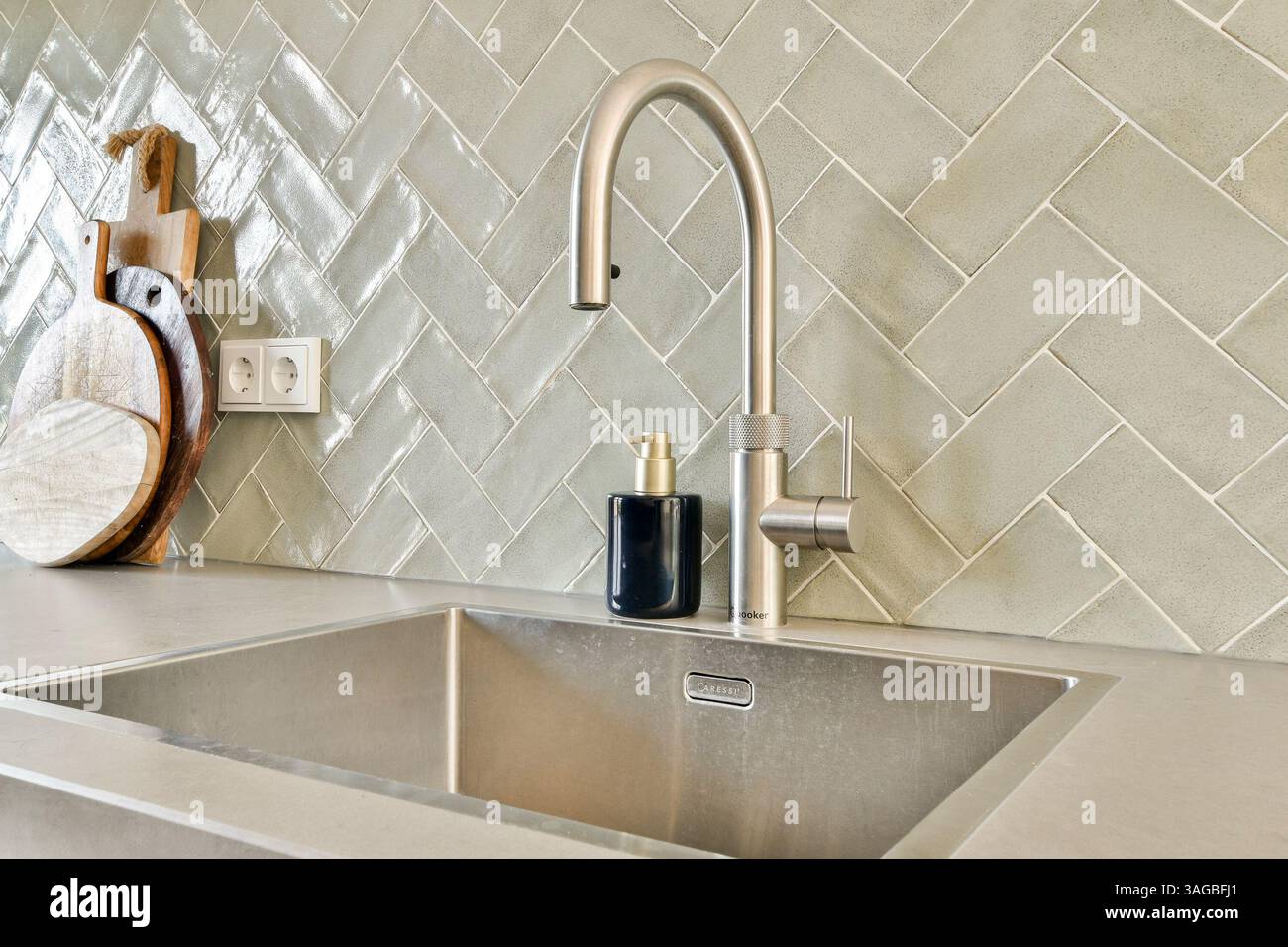 A sleek, modern kitchen sink featuring a contemporary faucet, set ...