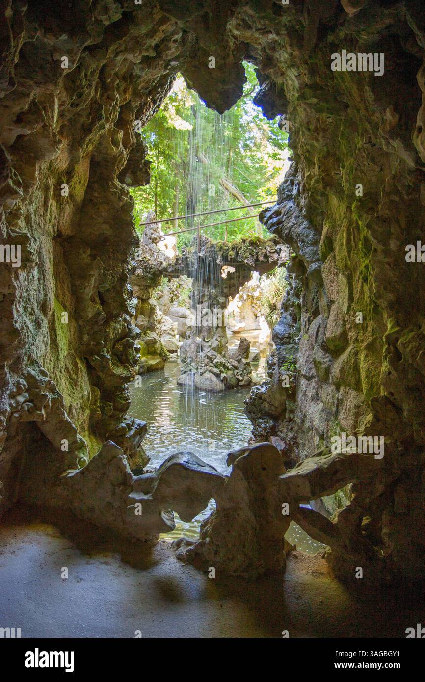 Mystical cave passage with stepping stones over a reflective pond at ...