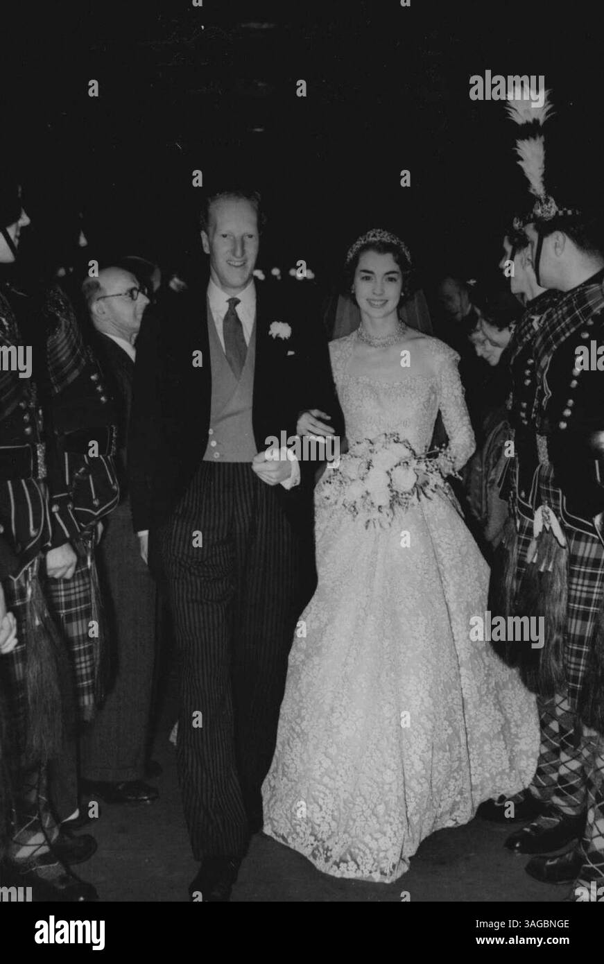 Photo shows: The bride and bridegroom leaving after the ceremony. The guard of honour is ...