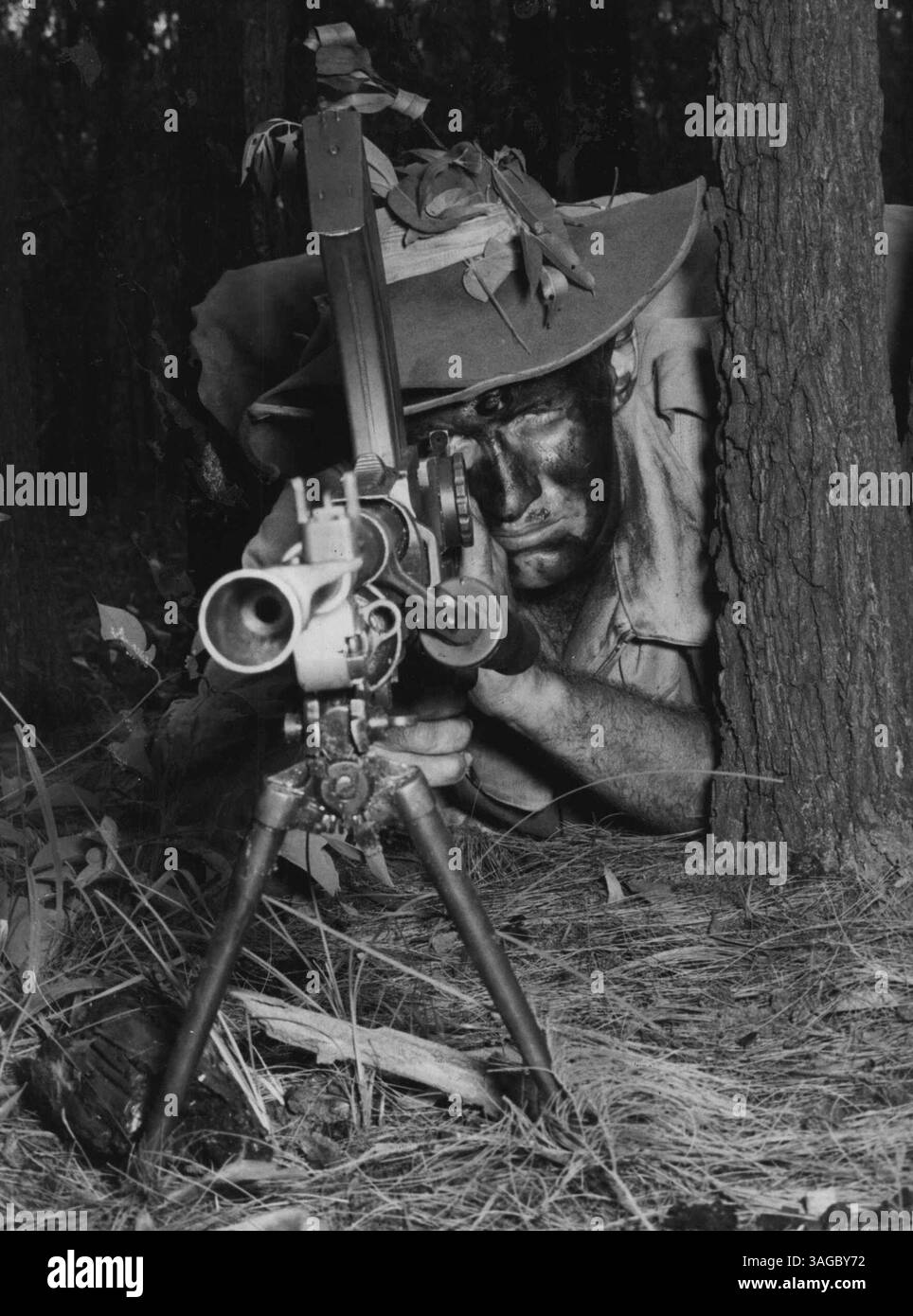 Blacked-out gunman Pte. W. Roth, 21, of Bundaberg, takes cover and ...