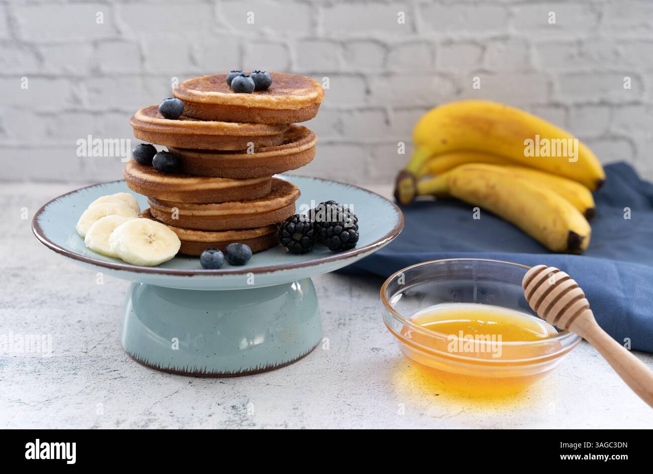 Sweet and fluffy stacked pancakes adorned with banana and berries ...