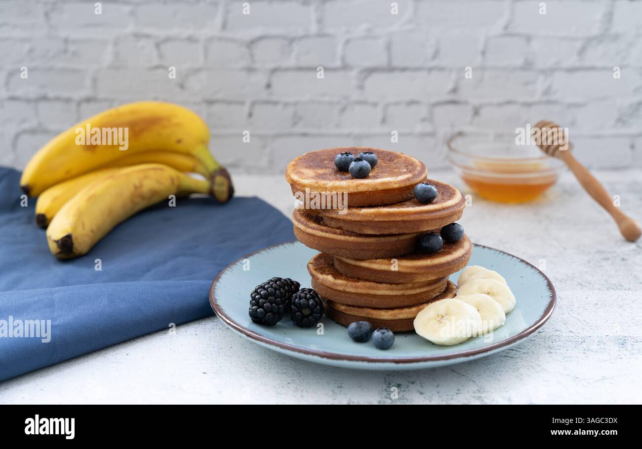 Sweet and fluffy stacked pancakes adorned with banana and berries ...