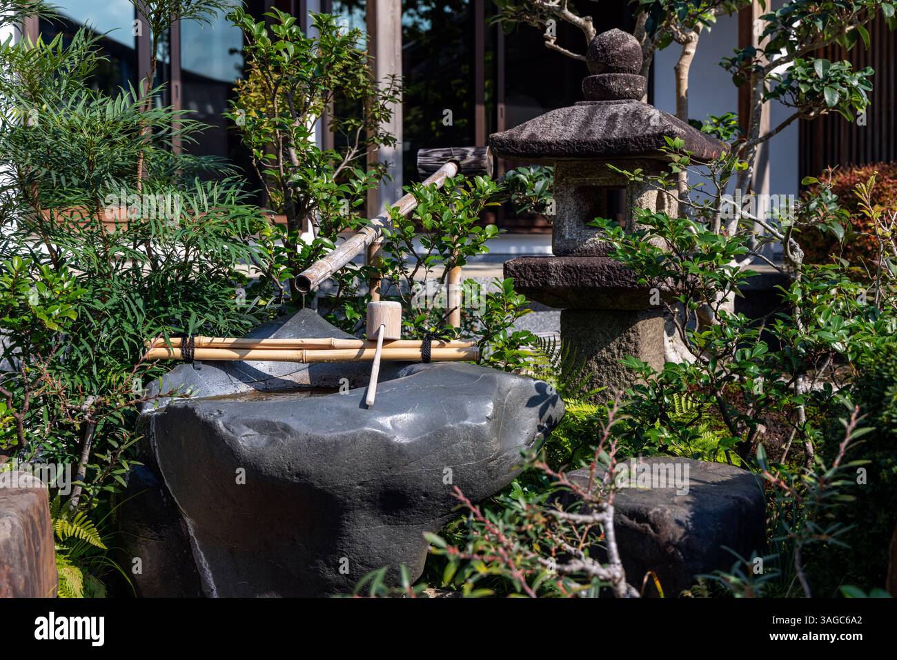 Shishi-odoshi bamboo fountain and stone lantern in a Japanese Zen ...