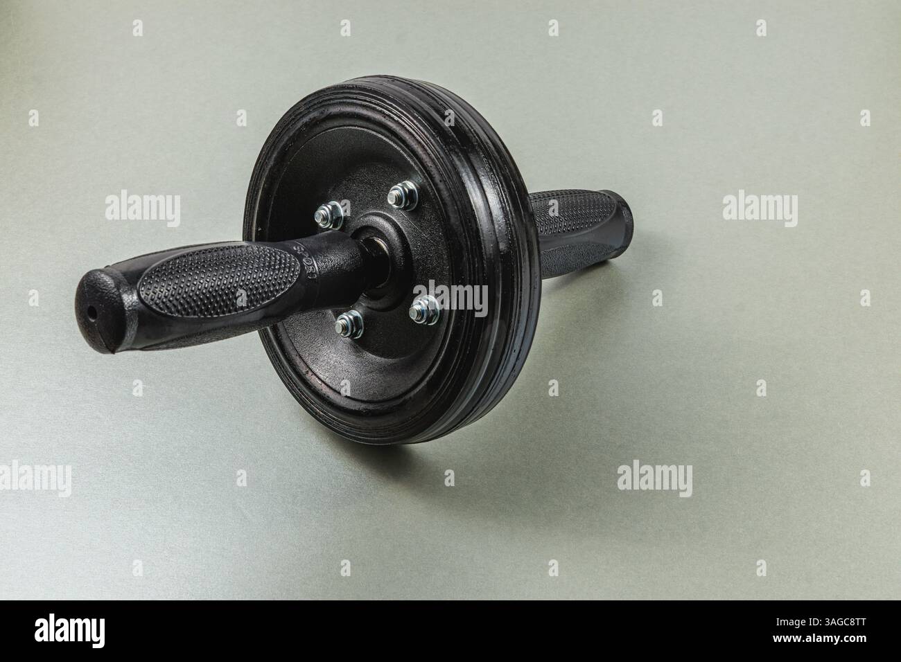 A black ab roller rests on a gray surface, highlighting its design for ...