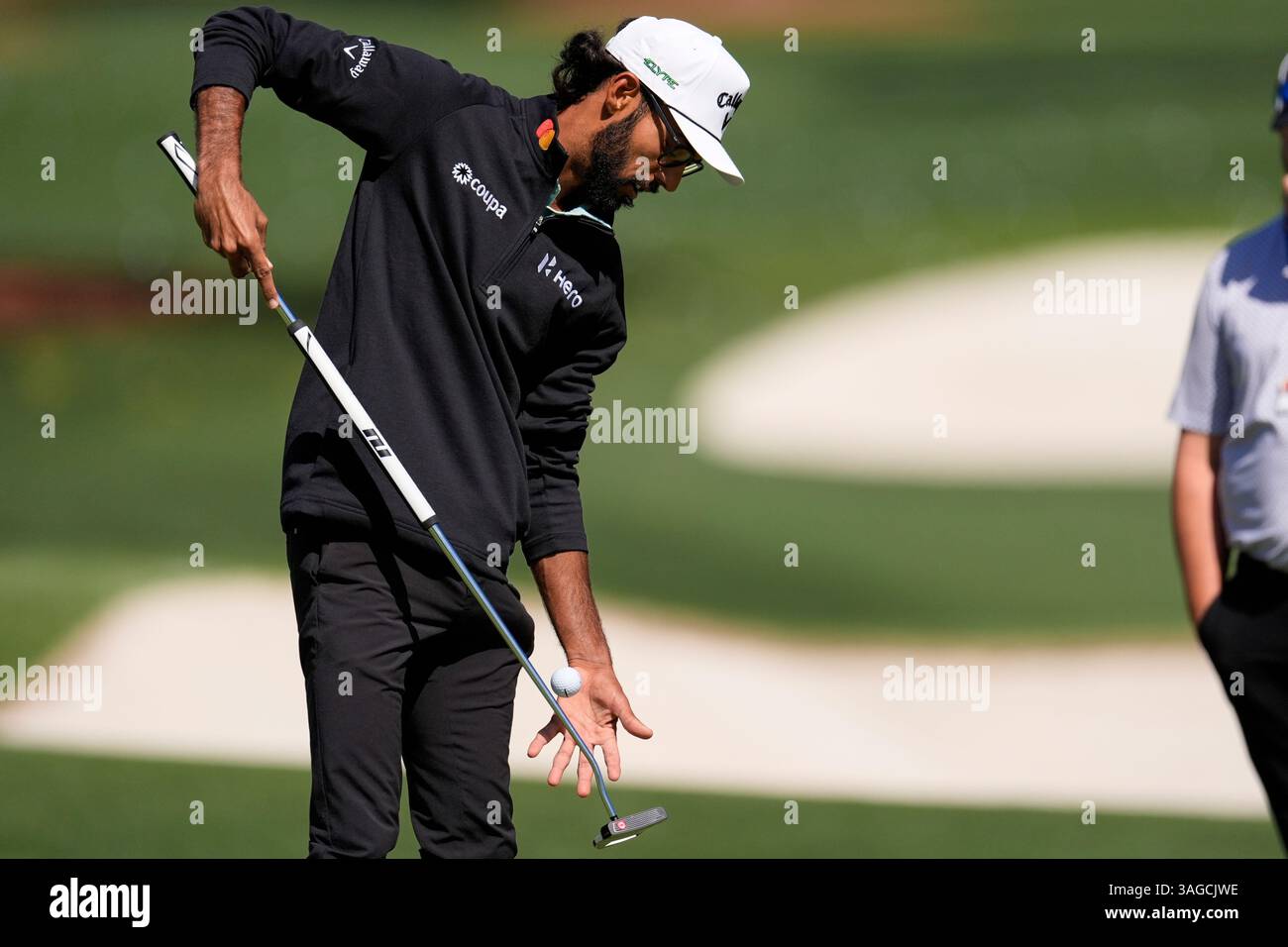 Akshay Bhatia picks up his ball on the putting green during a practice ...