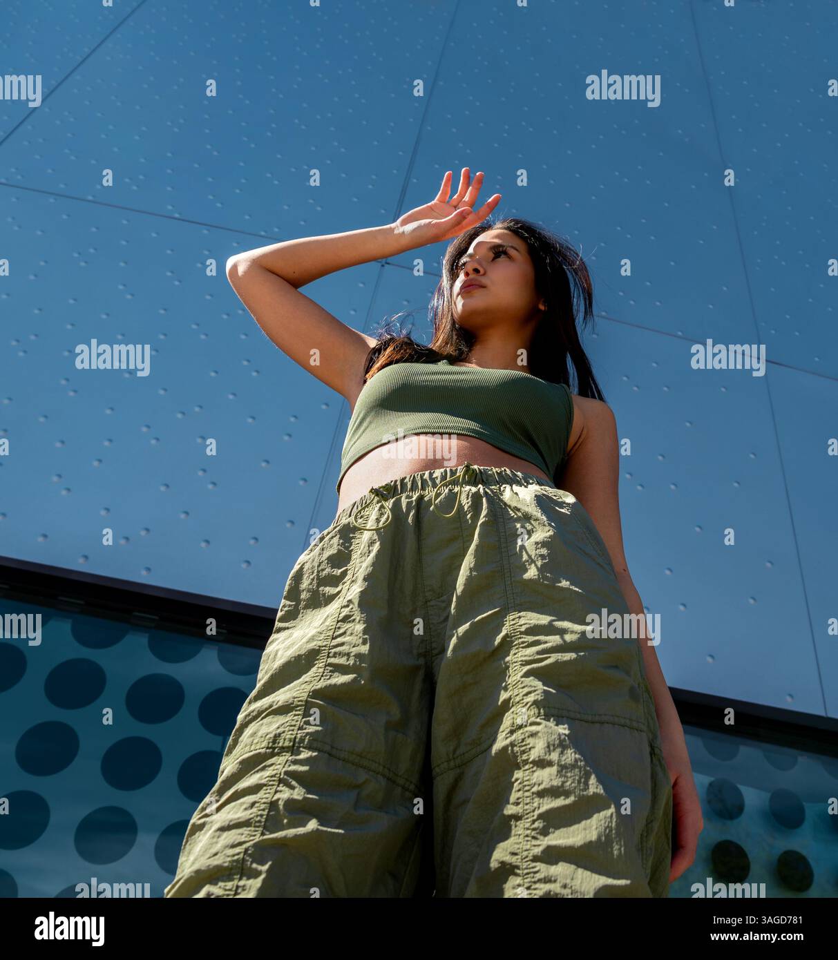 Beautiful Gen Z woman low-angle view portrait in front of a modern ...