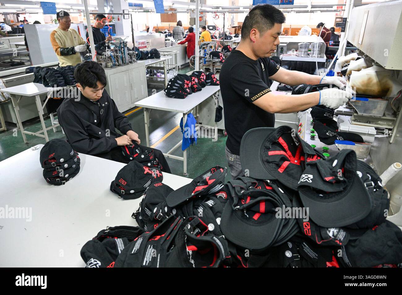 Workers make caps for export at a textile factory in Siyang county in ...