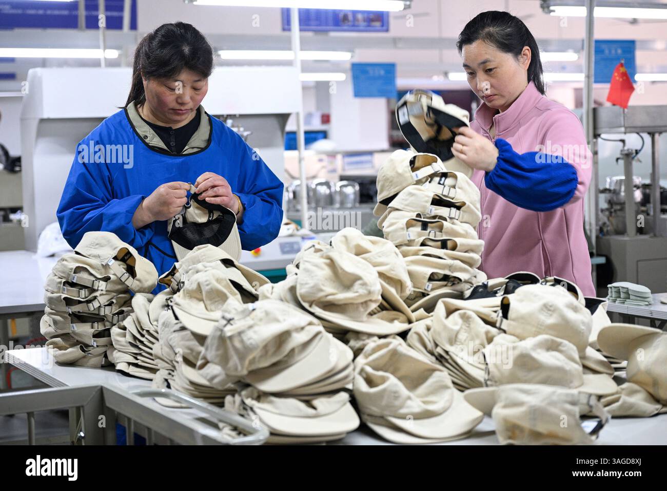Workers make caps for export at a textile factory in Siyang county in ...
