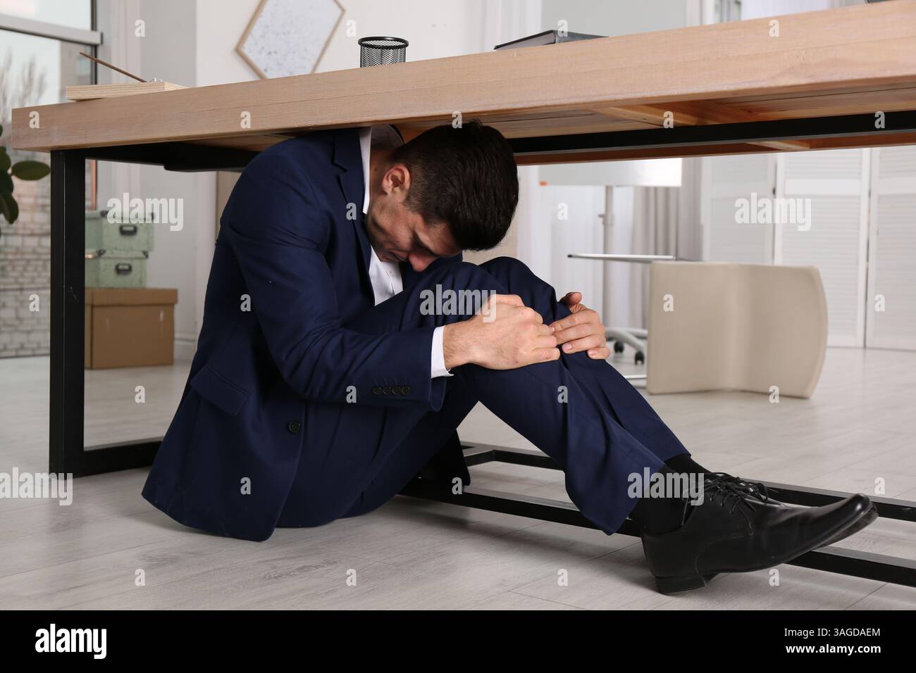 Person hiding under desk hi-res stock photography and images - Alamy