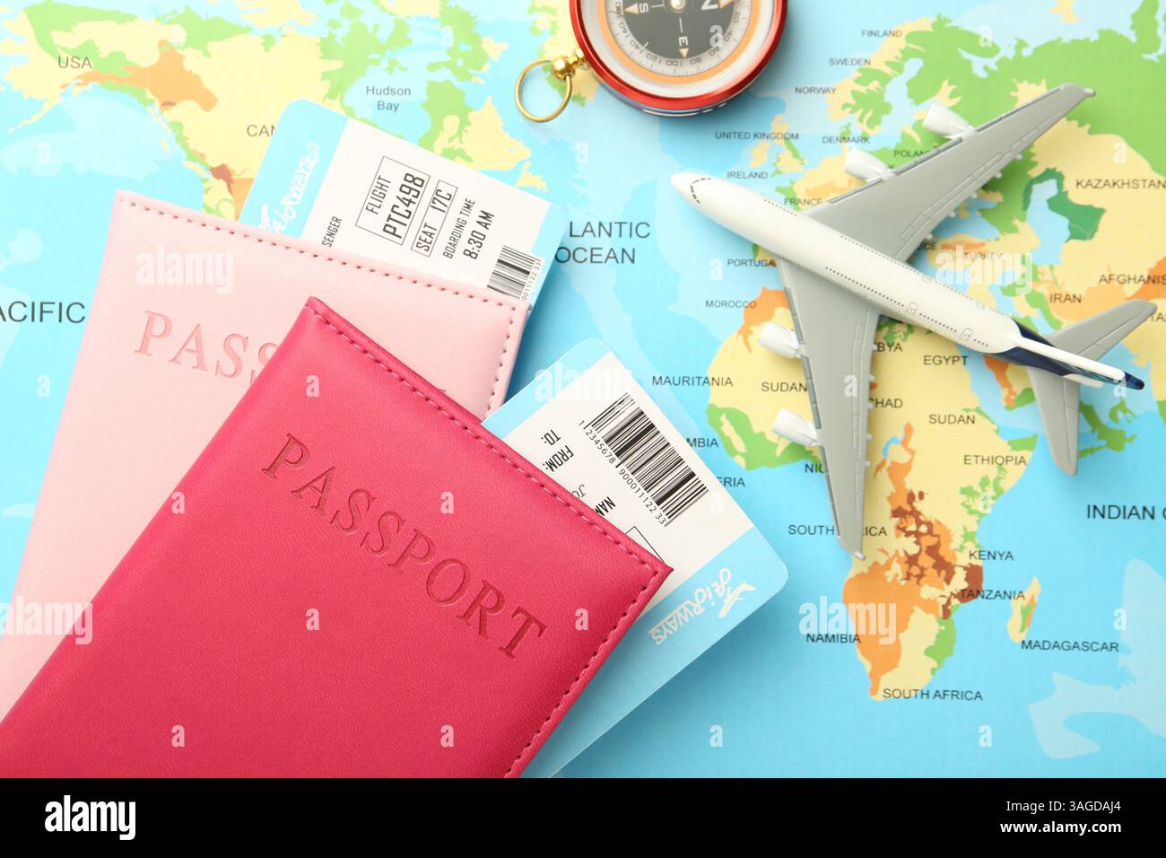 Passports with tickets, compass and plane model on world map, flat lay ...