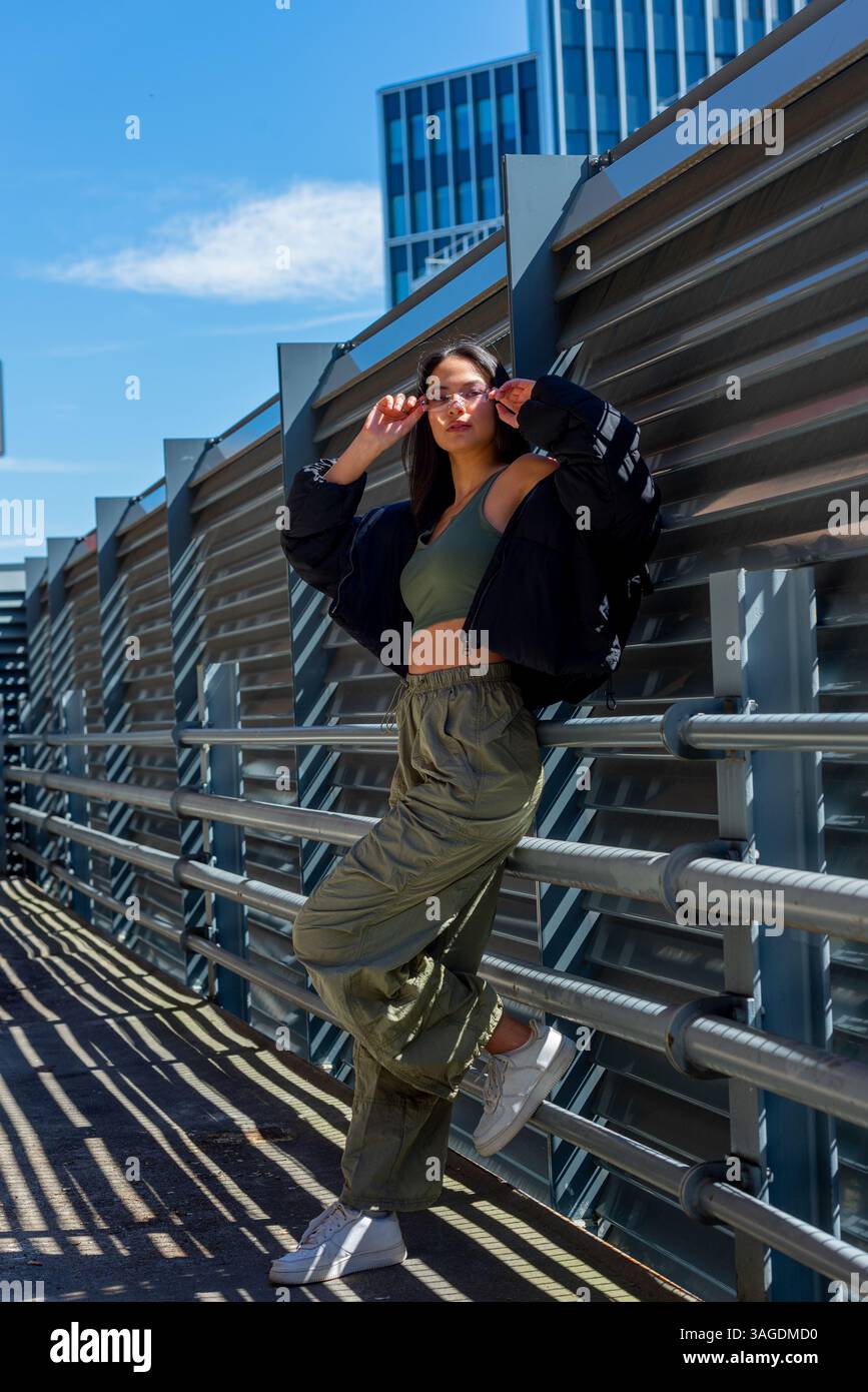 Cool attitude Gen Z woman posing in an urban setting in a parking ...