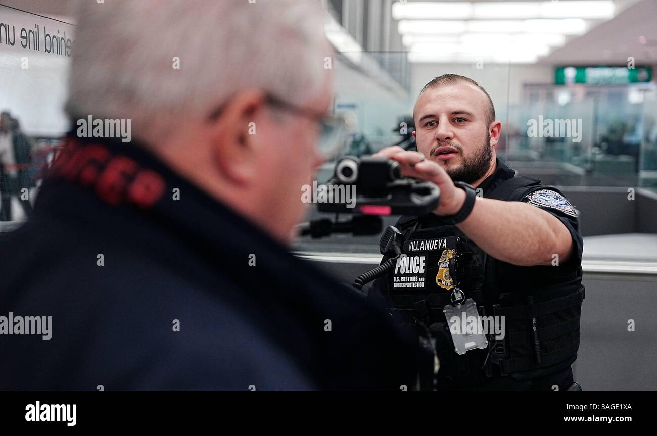 A U.S. Customs and Border Protection officer photographs a passenger ...
