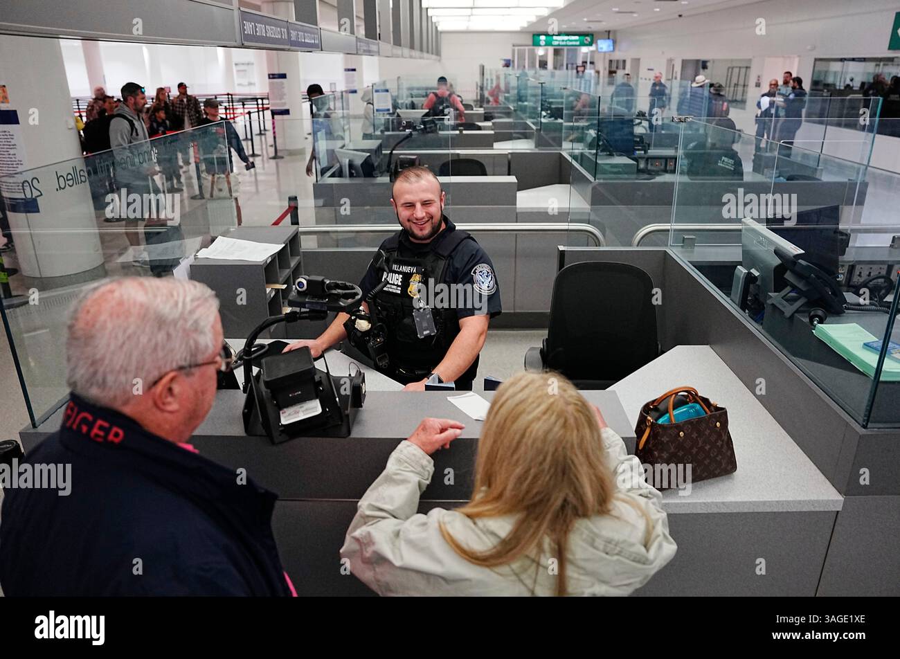 A U.S. Customs and Border Protection officer processes travelers ...
