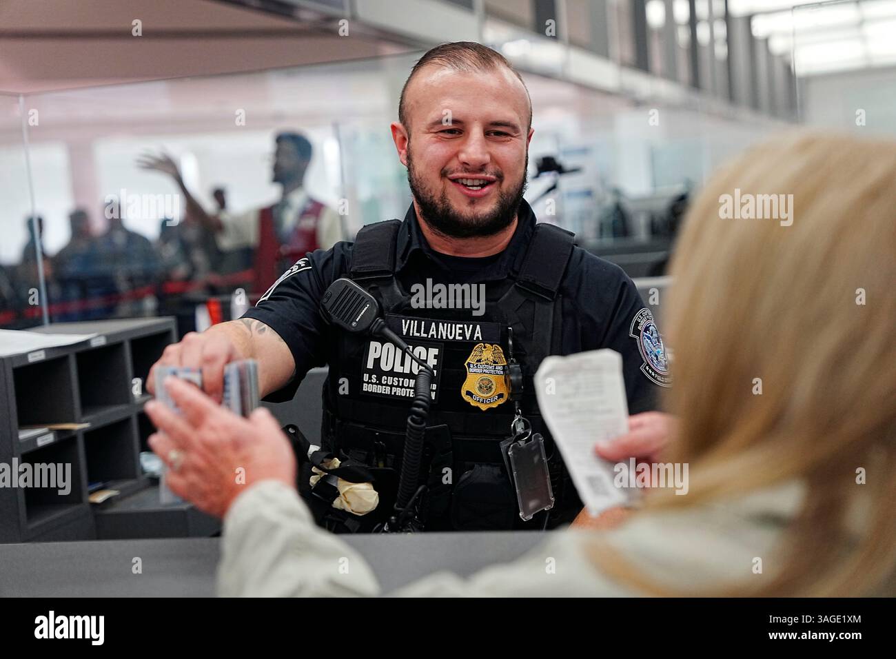 A U.S. Customs and Border Protection officer processes travelers ...