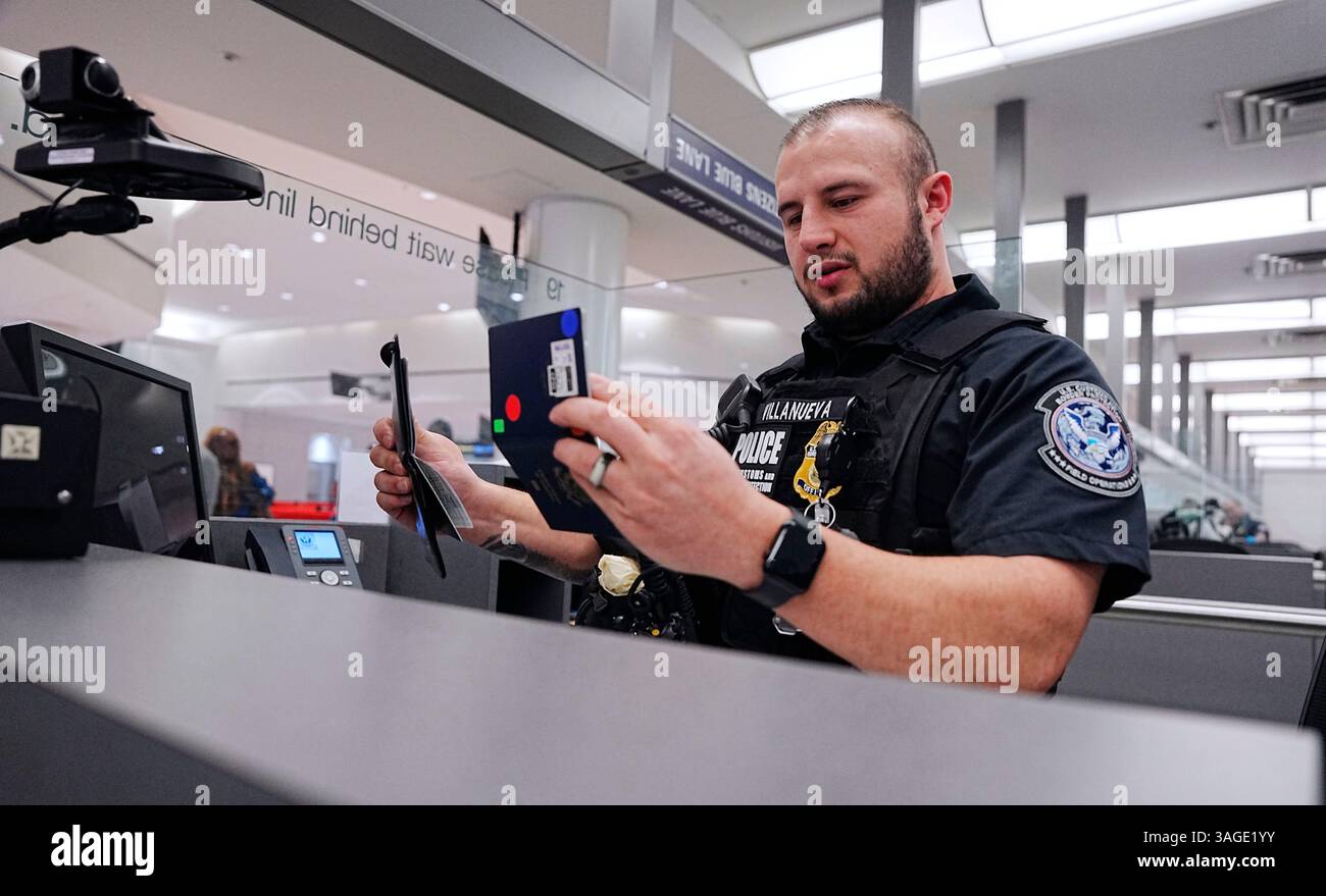 A U.S. Customs and Border Protection officer processes travelers ...