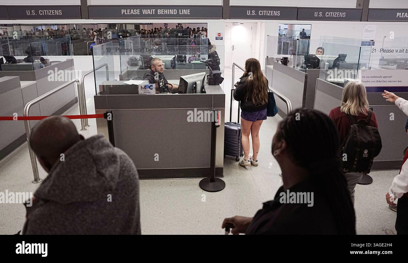 A U.S. Customs and Border Protection officer processes travelers ...