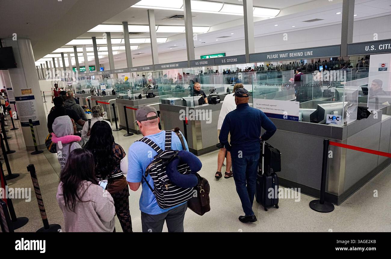 U.S. Customs and Border Protection officers process passengers arriving ...