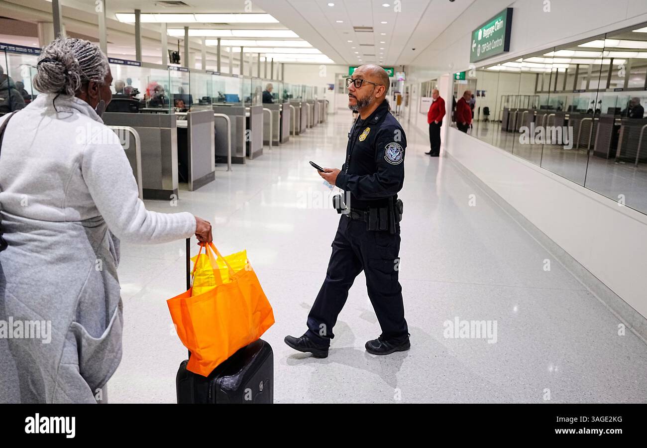 A U.S. Customs and Border Protection officer processes travelers ...