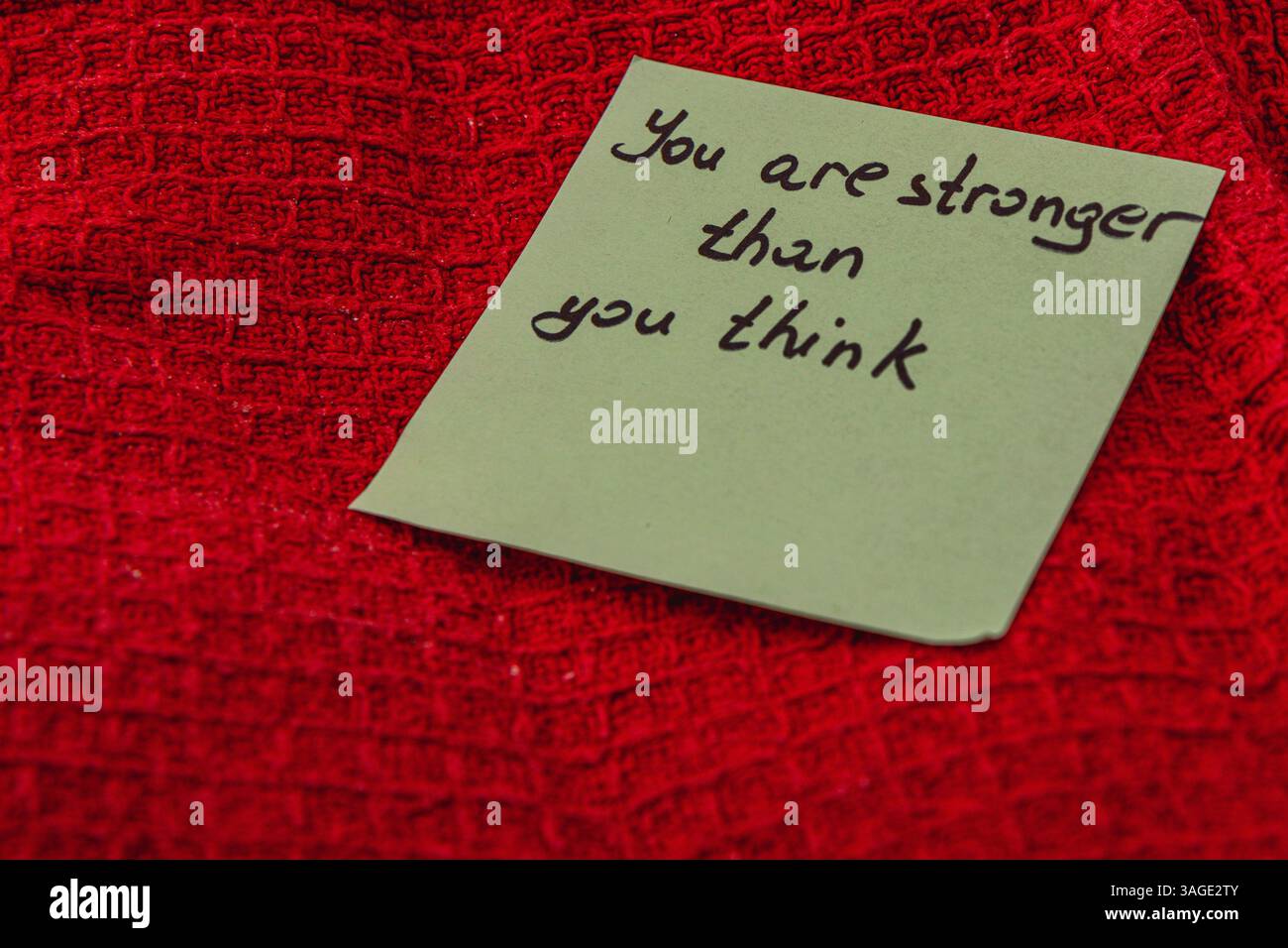 A handwritten note reading You are stronger than you think rests on a ...