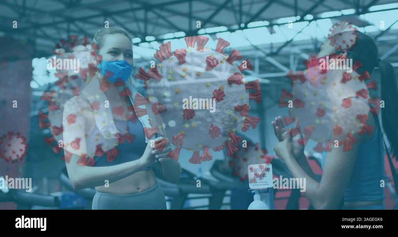 Covid-19 cells floating against two women wearing face masks sanitizing ...