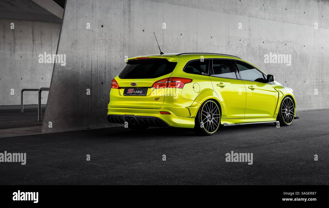 Lime green Focus ST parked near concrete wall of modern building. Three ...
