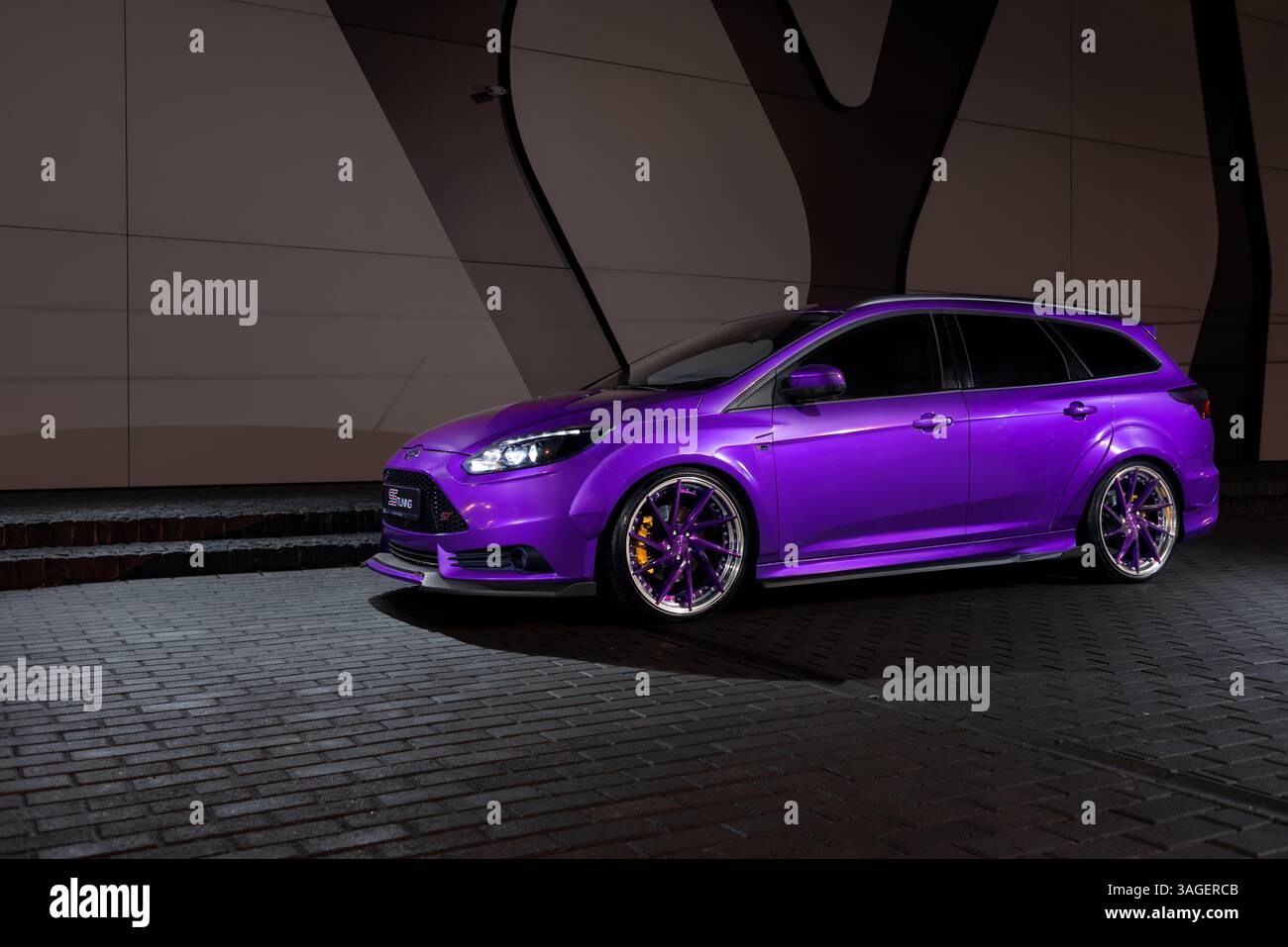 Purple Ford Focus mk3 parked near modern beige building at night. Front ...