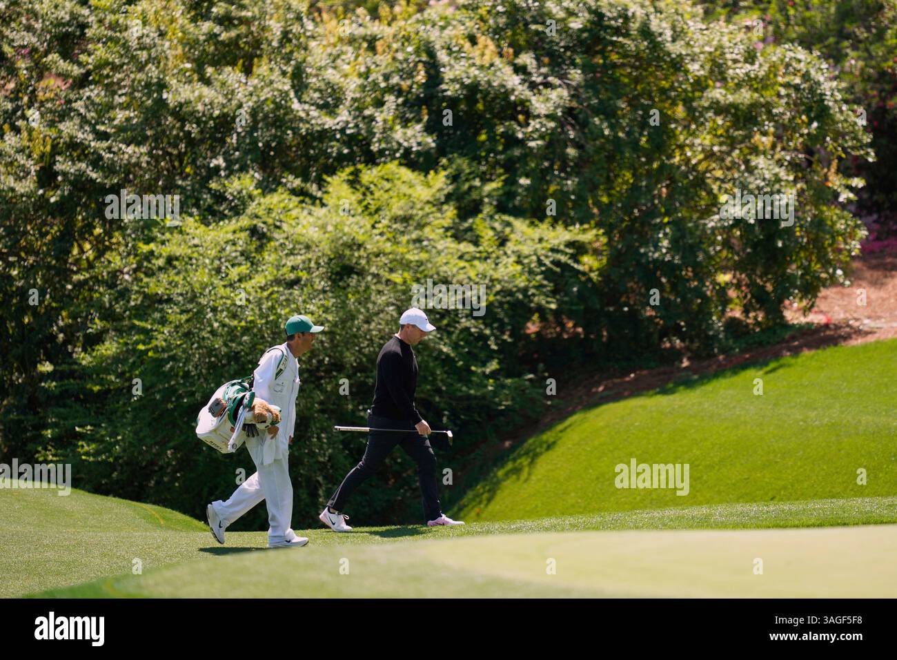Rory McIlroy, of Northern Ireland, walks up the 13th fairway with ...