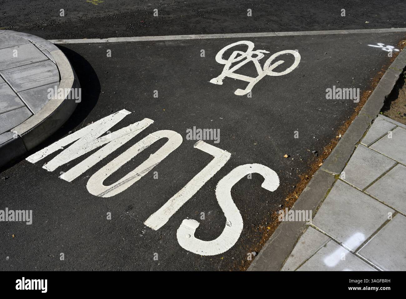Cycle path symbol of bike with word slow next to pavement Stock Photo ...