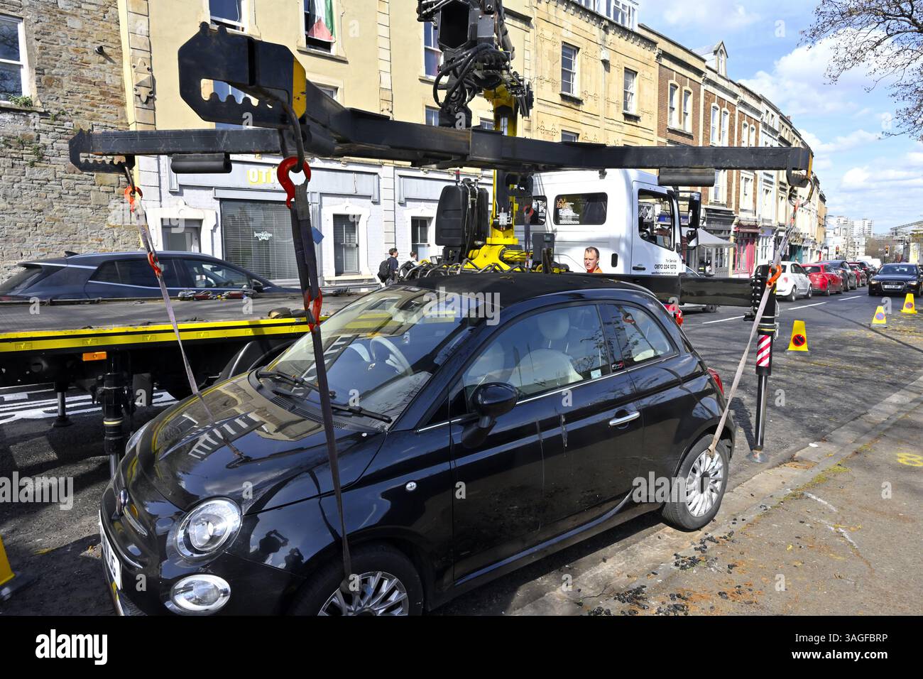 Car being lifted onto back of tow truck to move it to another location ...