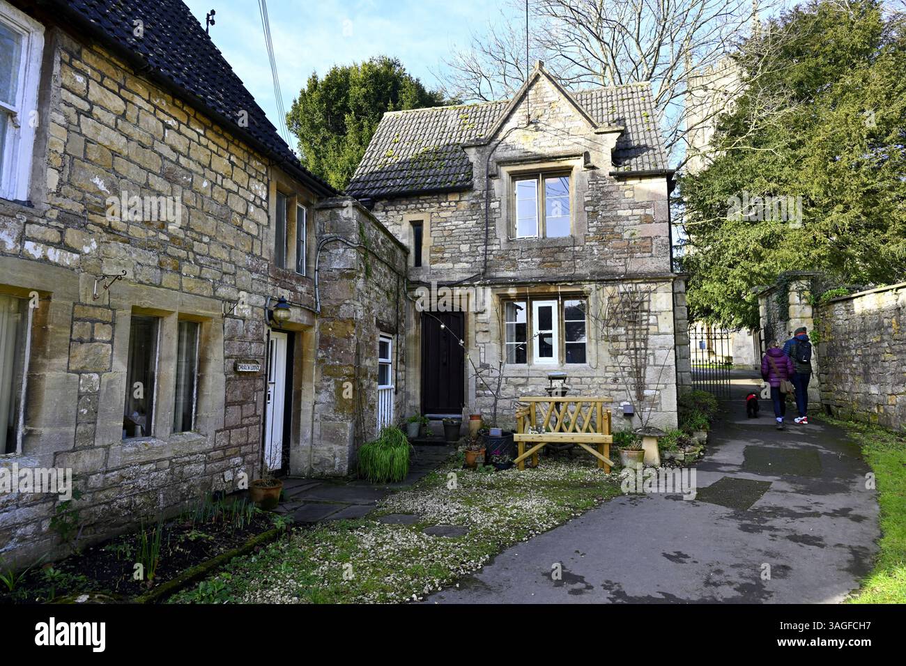 Public paved footpath in next to old stone build house market town of ...