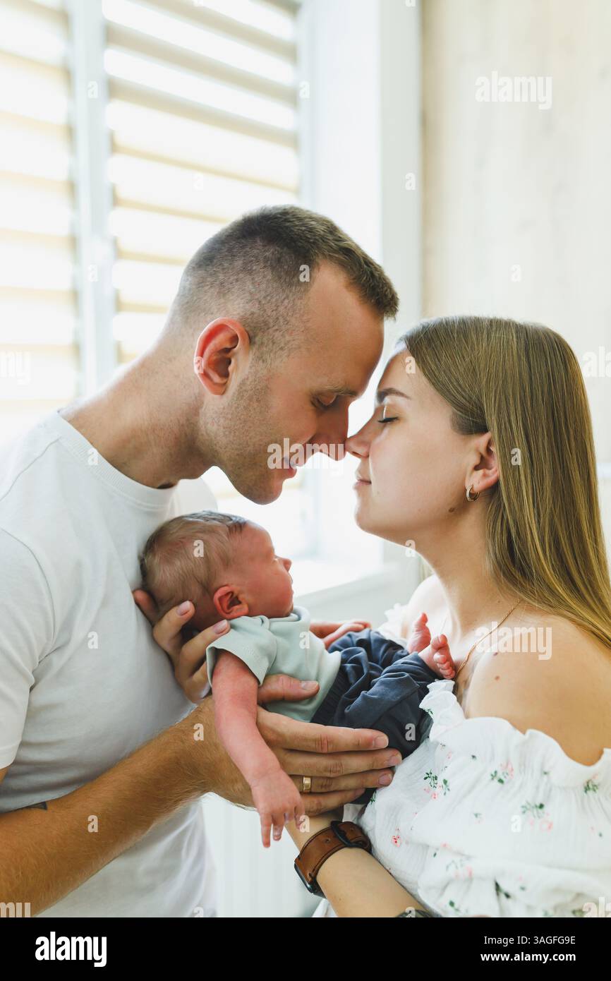 A loving mother and a devoted father gently share a sweet kiss while ...