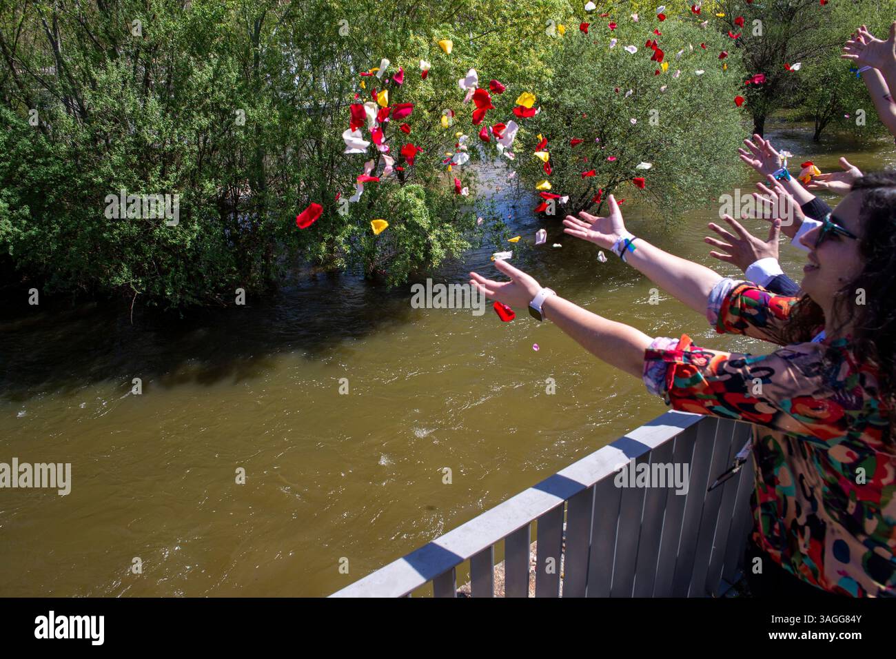 Women throw rose petals into the river, during the institutional act to ...