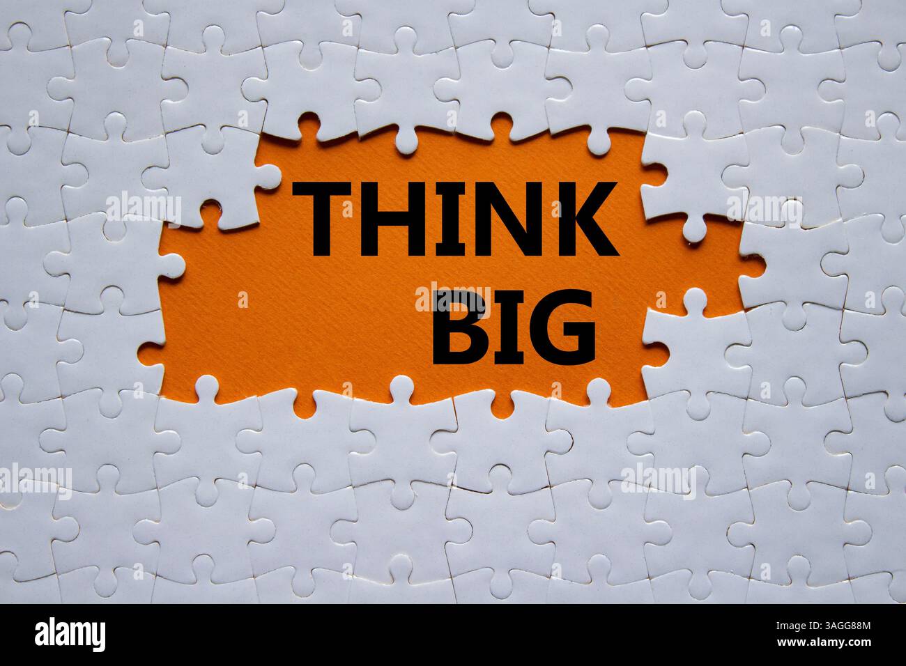 Think big symbol. White puzzle with words Think big. Beautiful orange ...