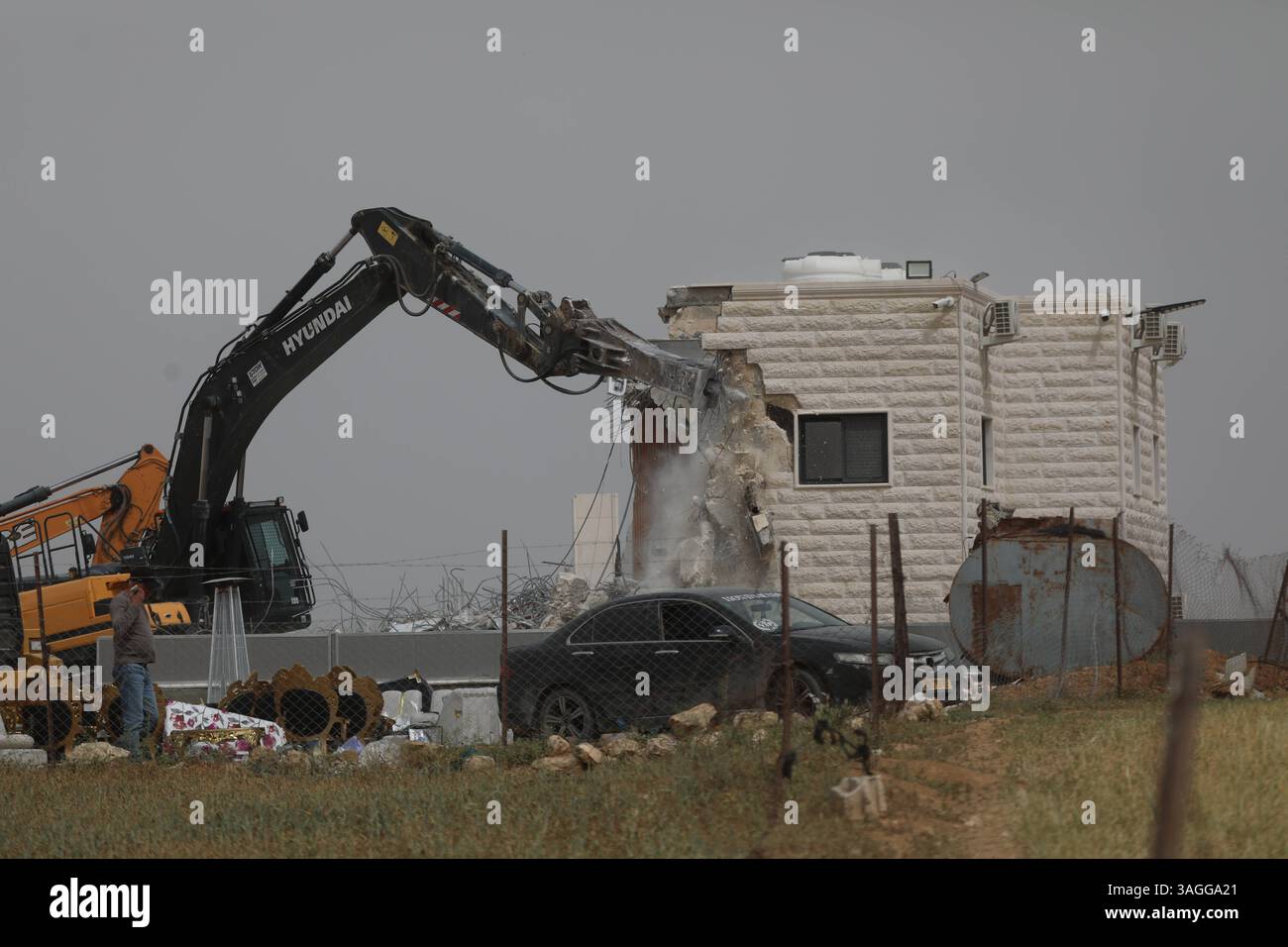 Israeli excavators equipped with breaker tools carry out the demolition ...