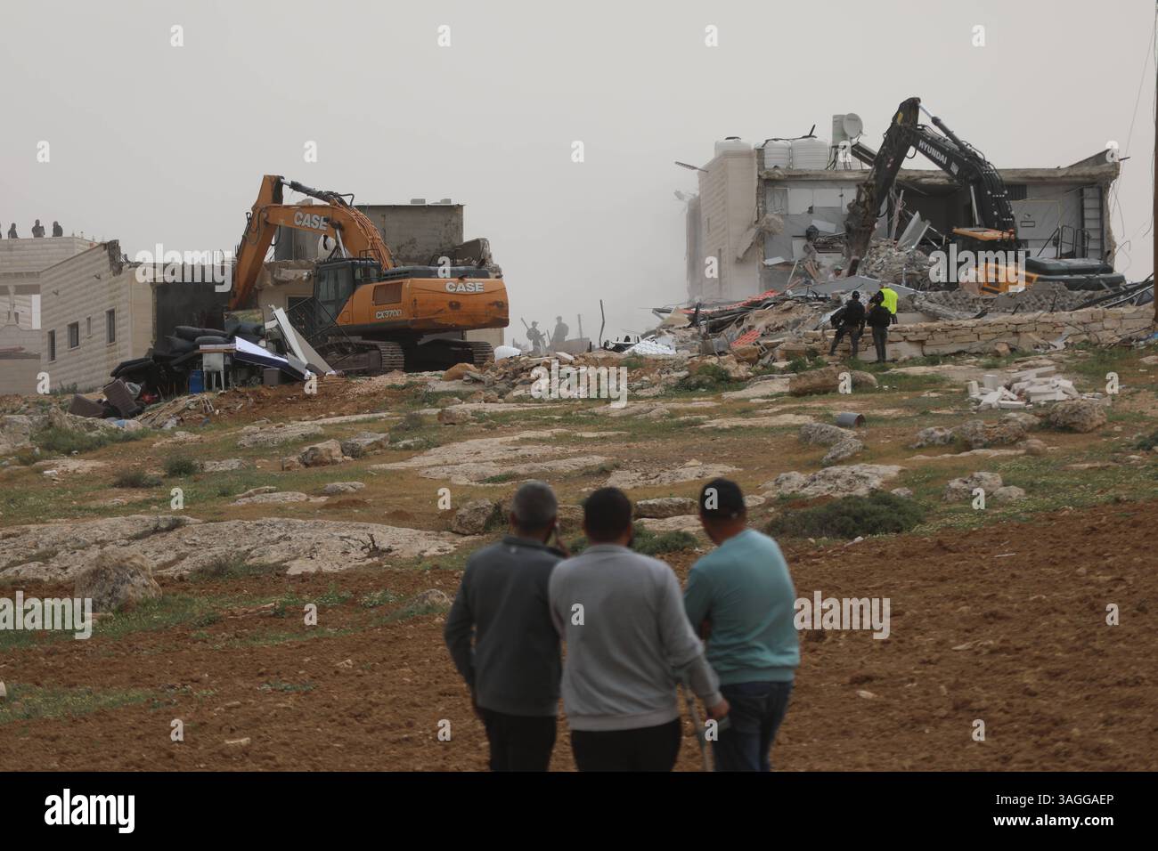 Israeli excavators equipped with breaker tools carry out the demolition ...