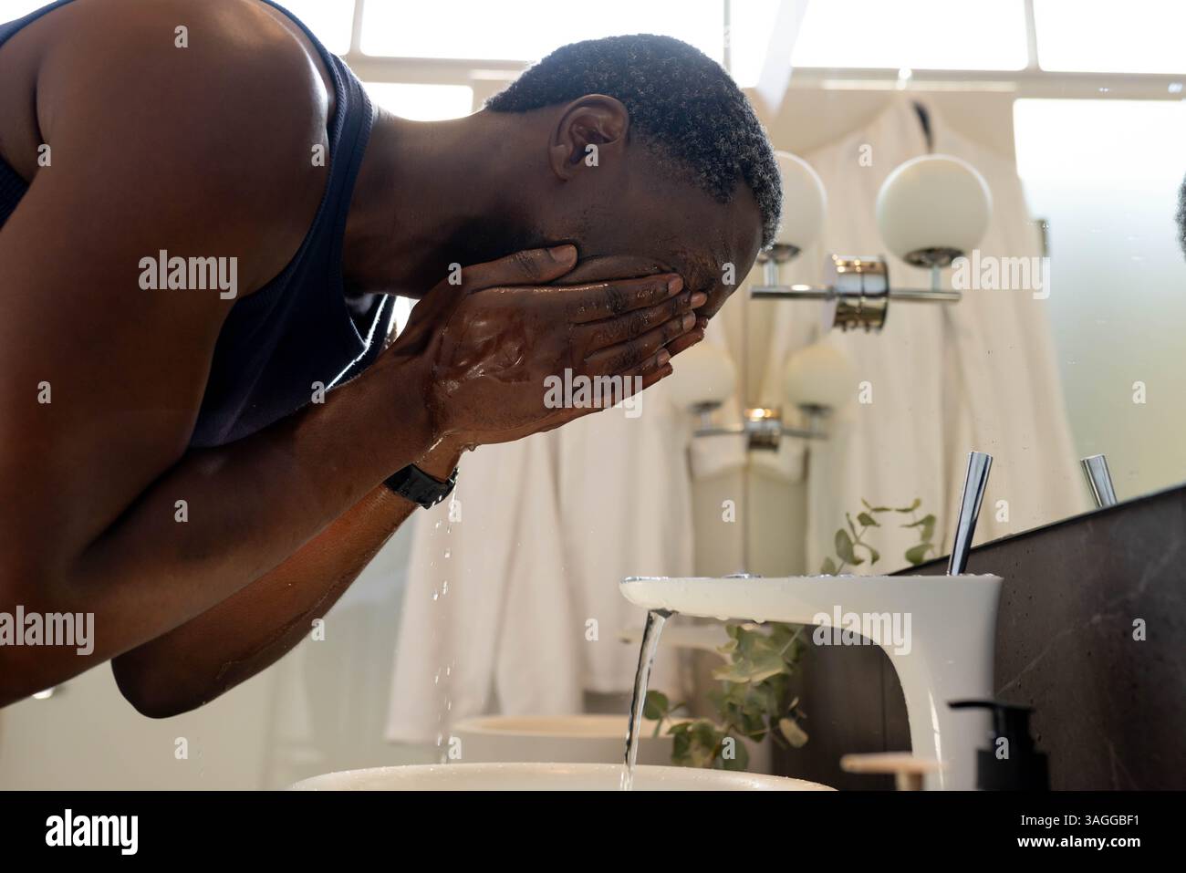 Washing face at bathroom sink, man refreshing morning routine. Hygiene ...