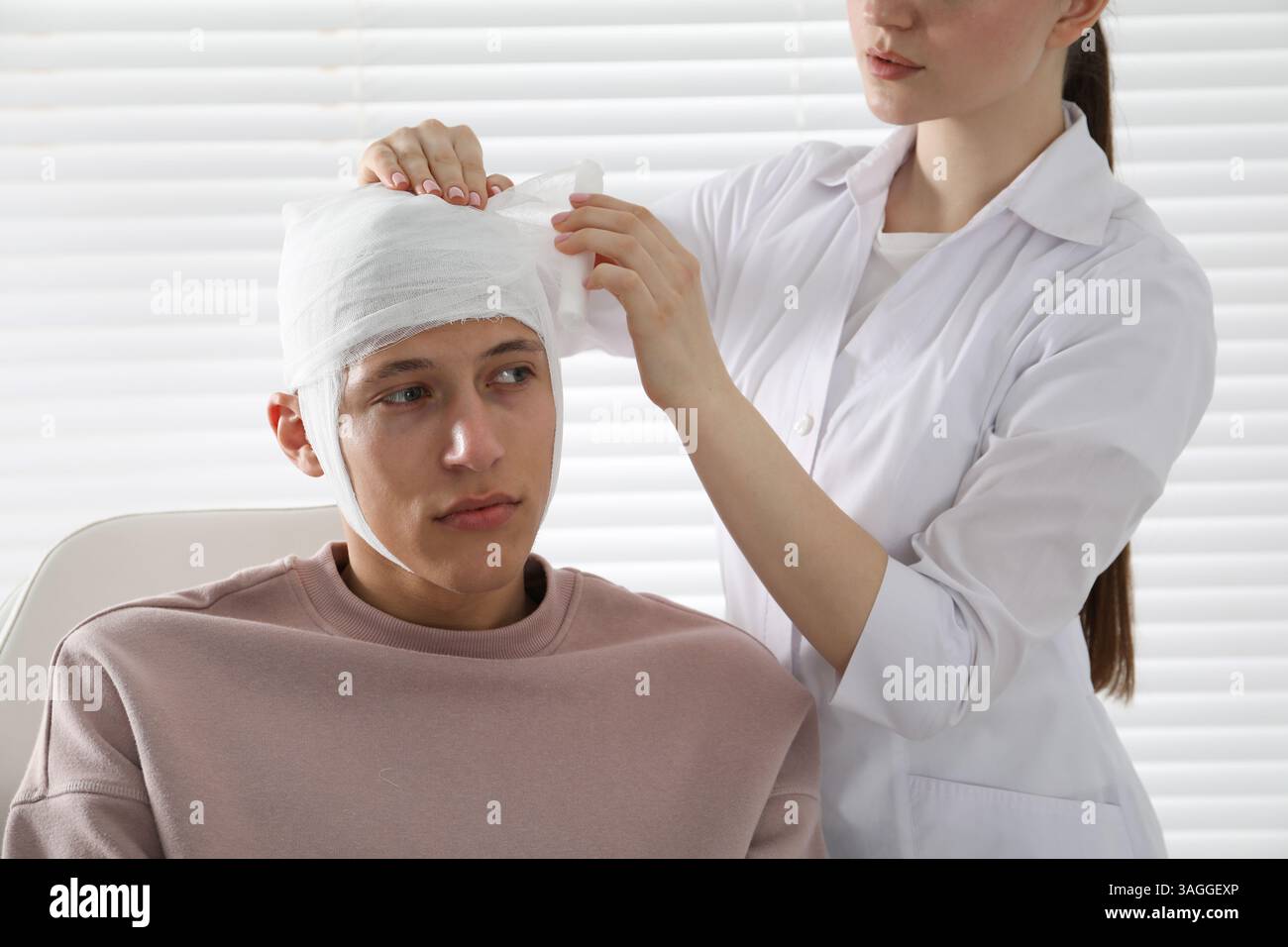 Doctor bandaging patient's head in clinic, closeup Stock Photo - Alamy