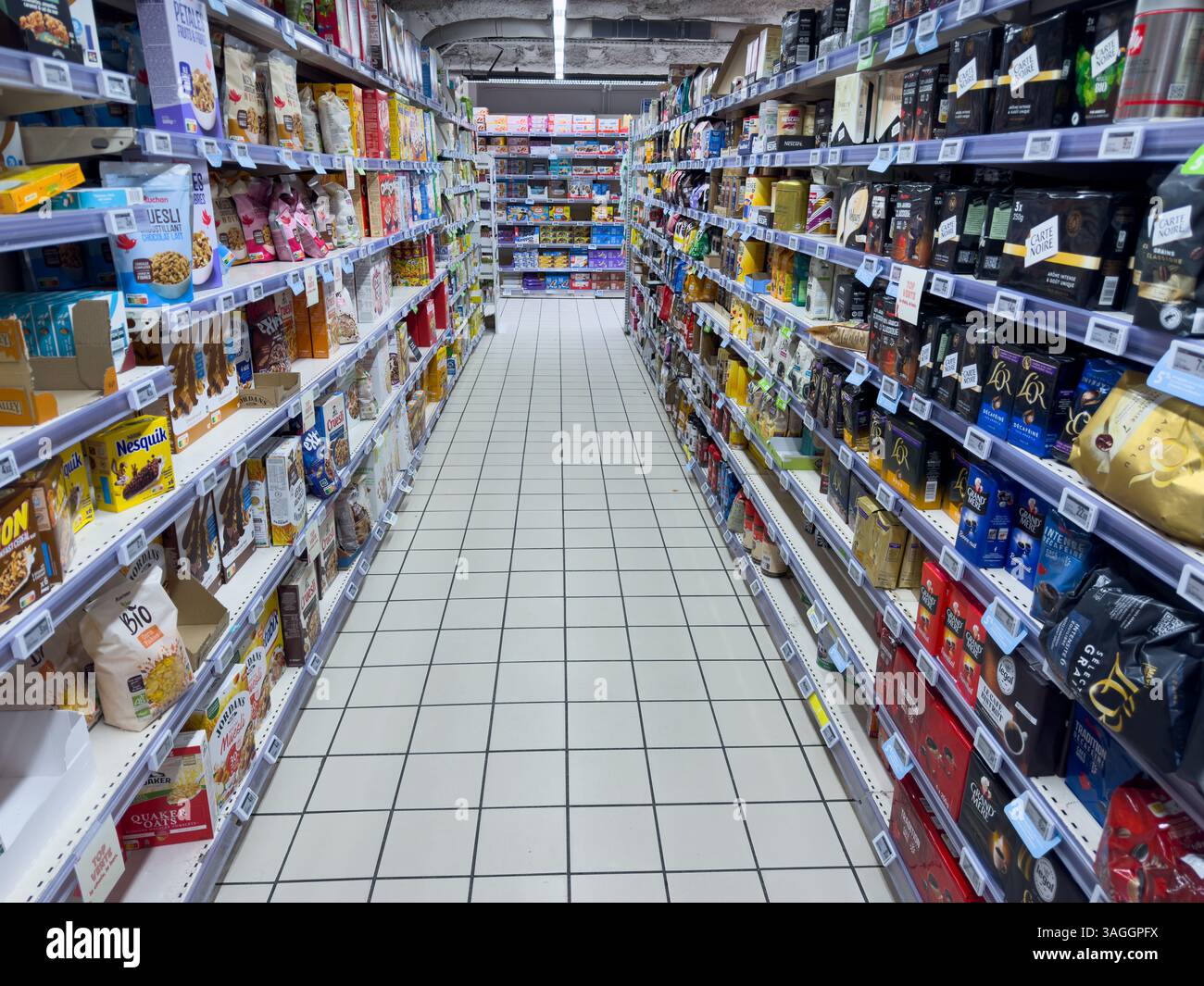 Brightly lit grocery aisle filled with diverse food products creating ...