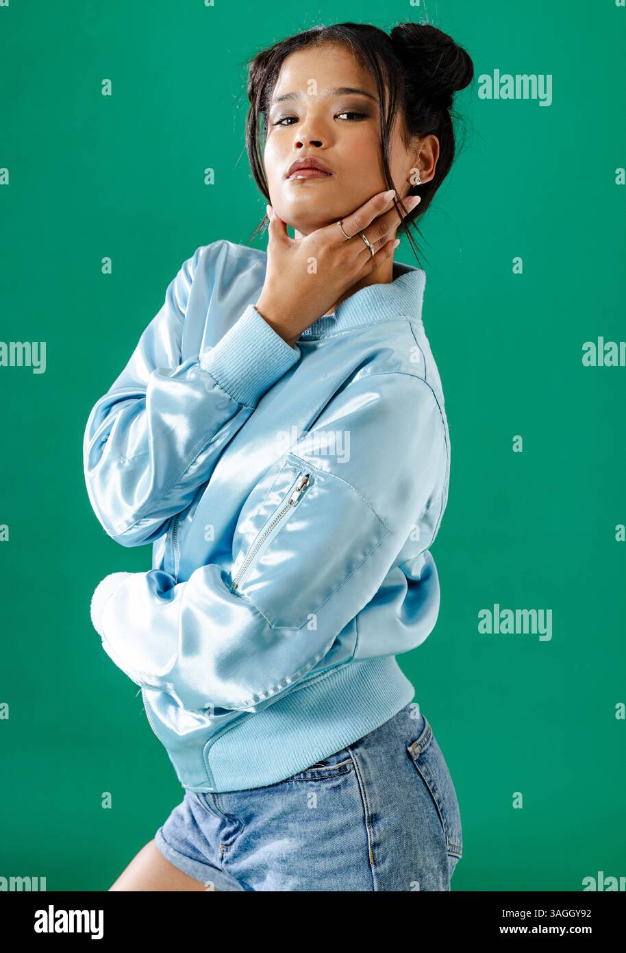 Confident Asian woman posing in blue jacket and denim shorts, striking ...