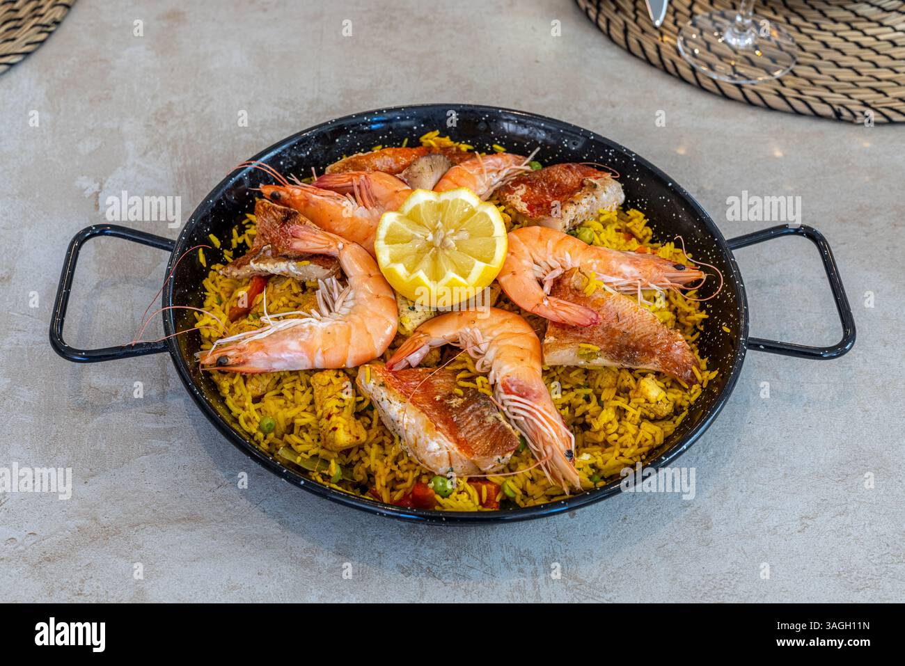 Close-up of a delicious seafood paella with shrimp and fish, garnished ...
