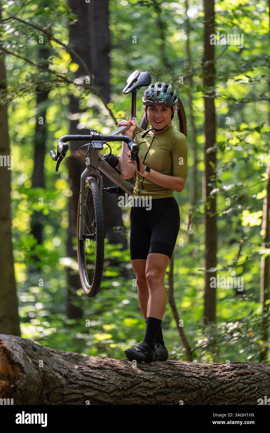 Professional cyclist in green cycling uniform holds gravel bike while ...