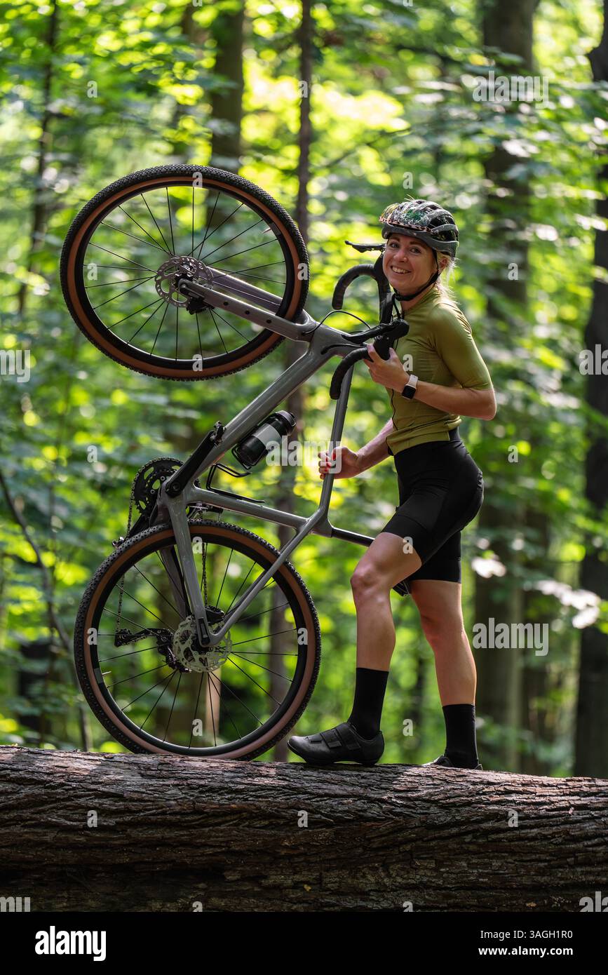 Professional cyclist in green cycling uniform holds gravel bike while ...