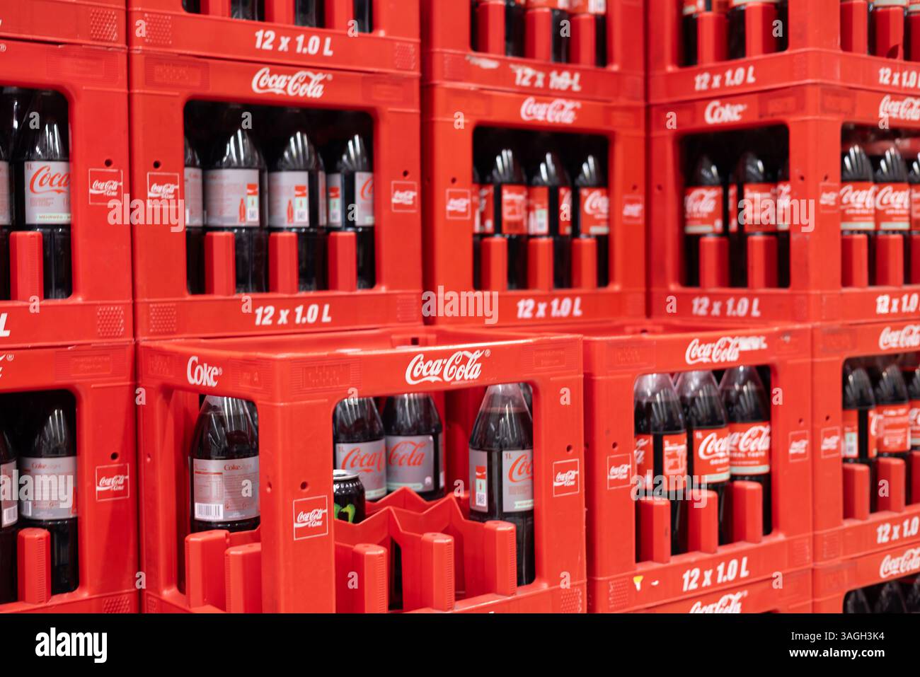 A neatly arranged stack of Coca-Cola bottles on red crates, emphasizing ...