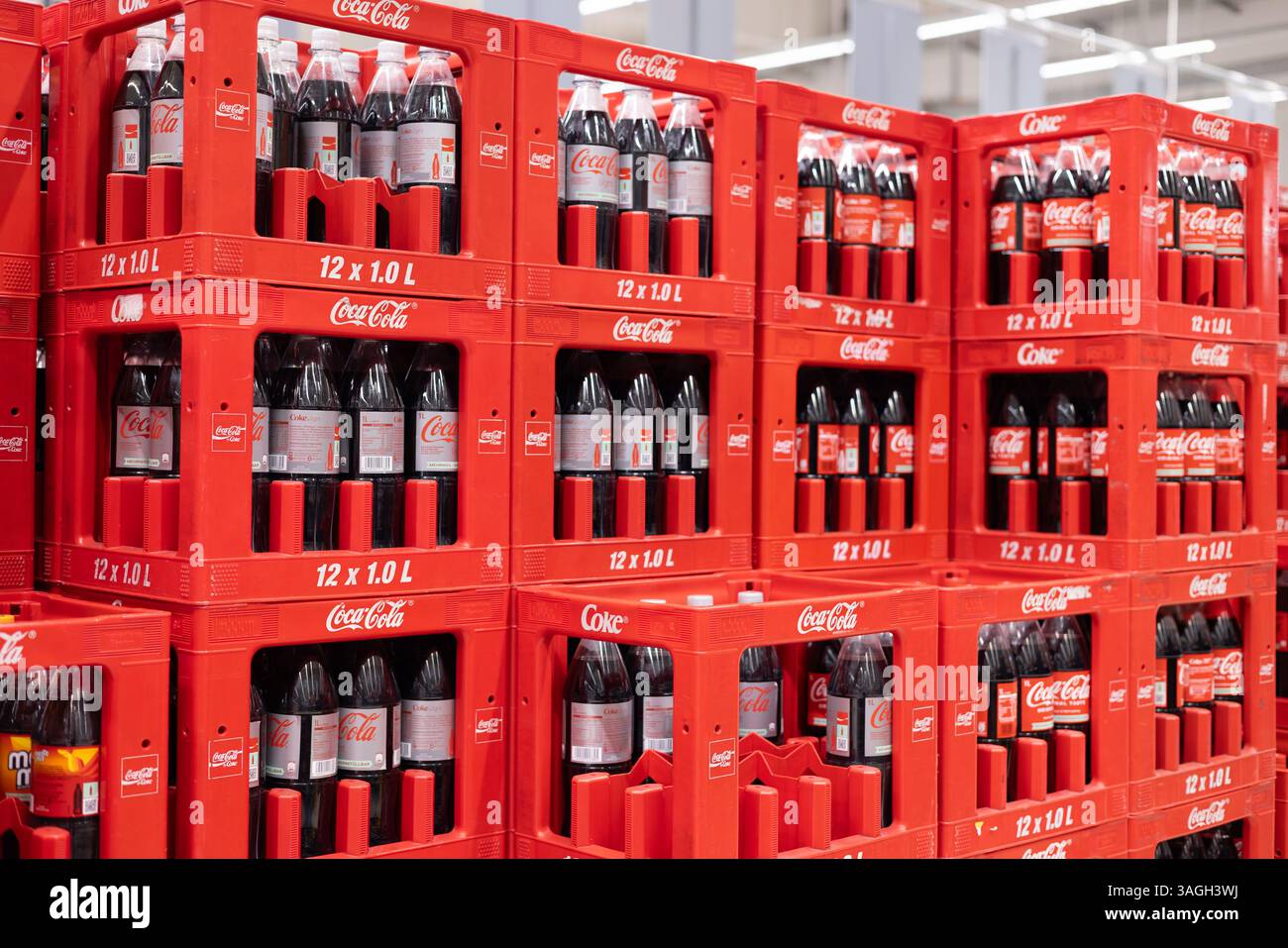 A neatly arranged stack of Coca-Cola bottles on red crates, emphasizing ...