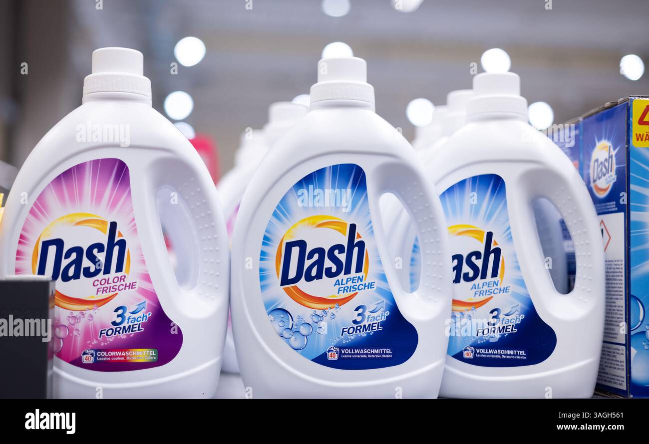 This image depicts bottles of Dash laundry detergent arranged in a ...