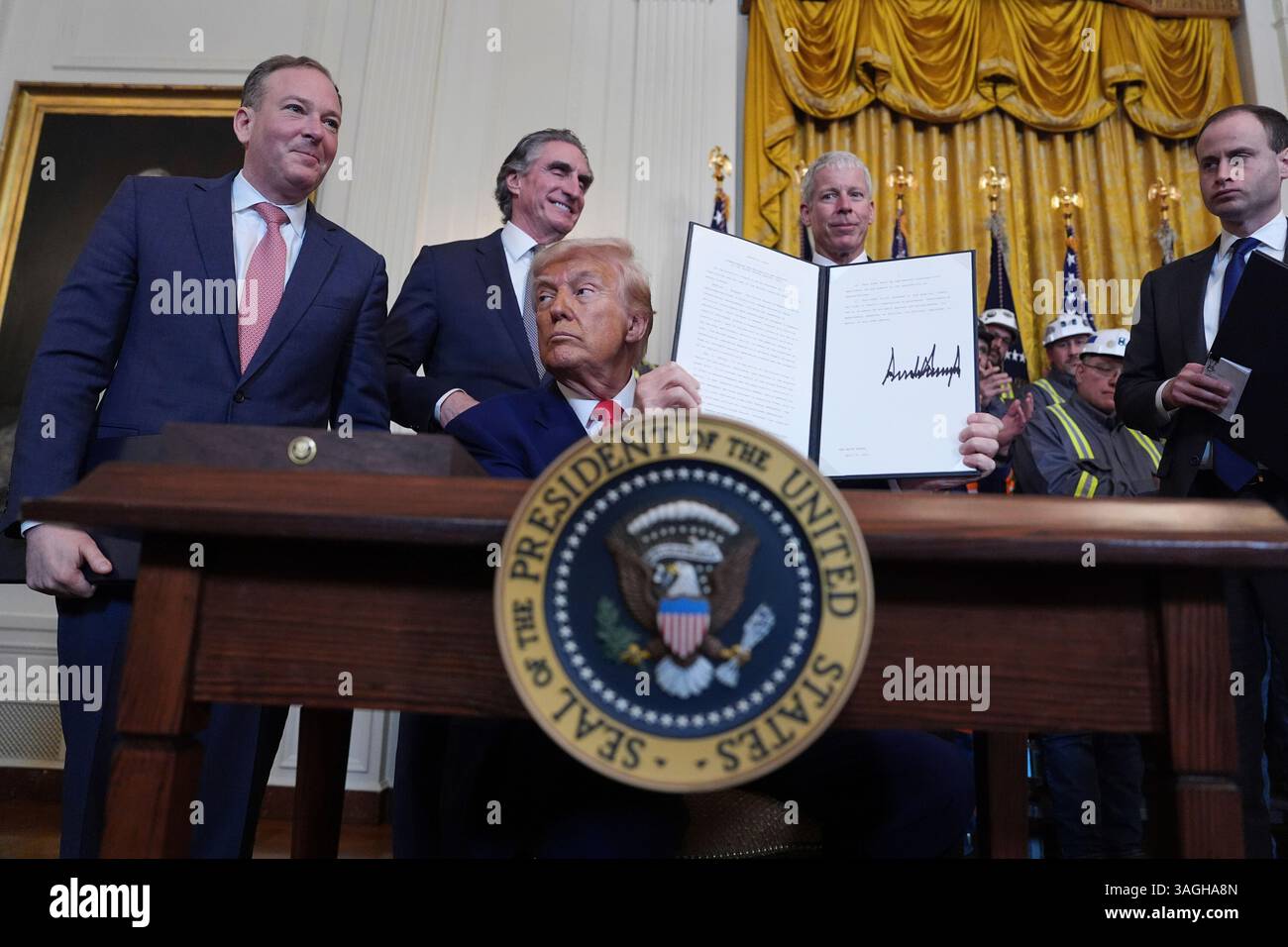 President Donald Trump holds a signed an executive order during an ...