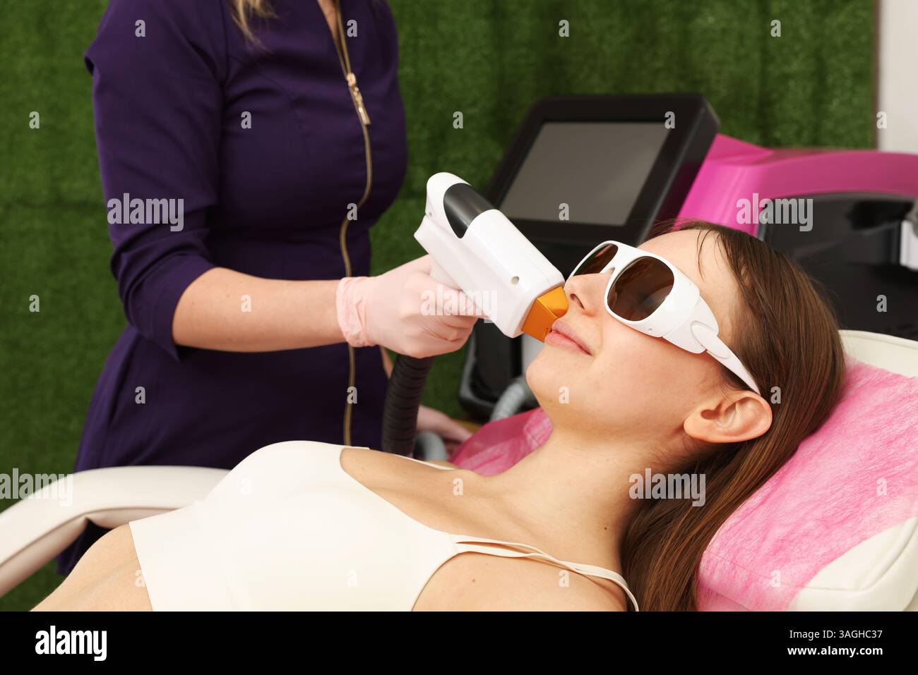 Woman undergoing laser depilation procedure in beauty salon Stock Photo ...