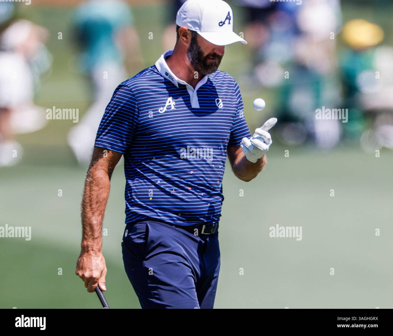 Dustin Johnson of the US catches his ball as he walks across the ...