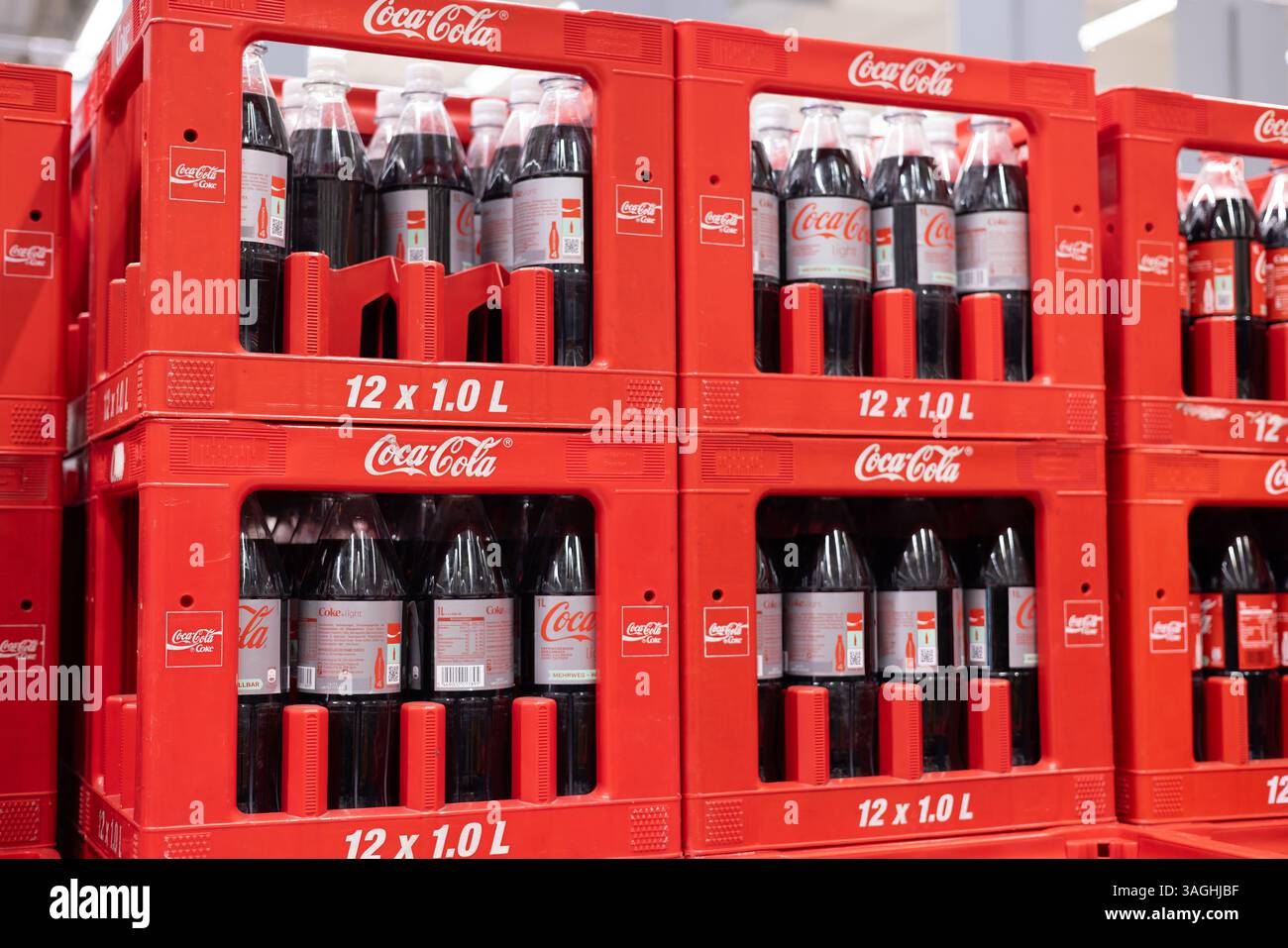 A neatly arranged stack of Coca-Cola bottles on red crates, emphasizing ...