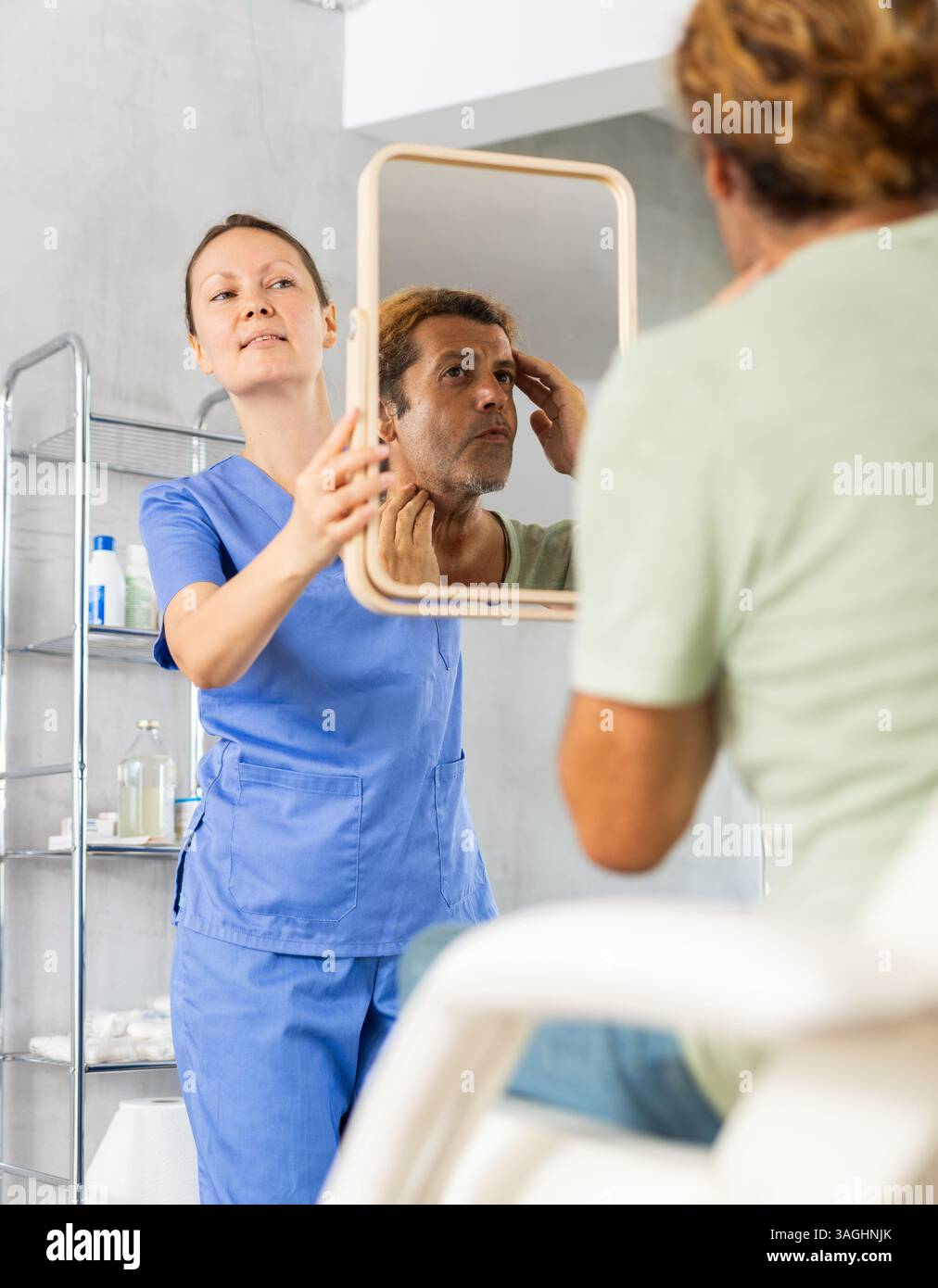 Man scrutinizing his own reflection in mirror held by female ...